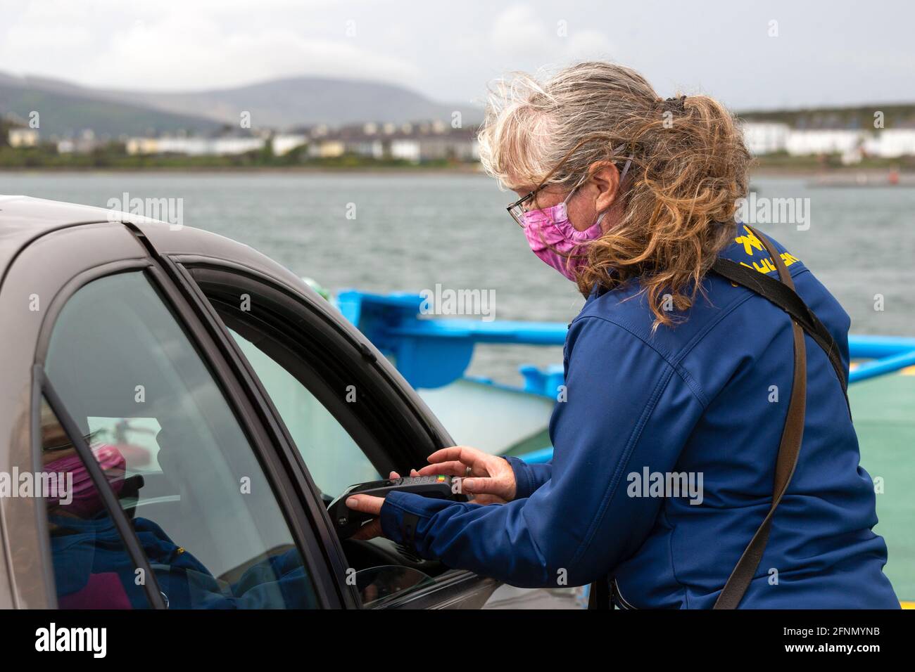 Deck supervisor collecting fares using mobile phone app, on the ...