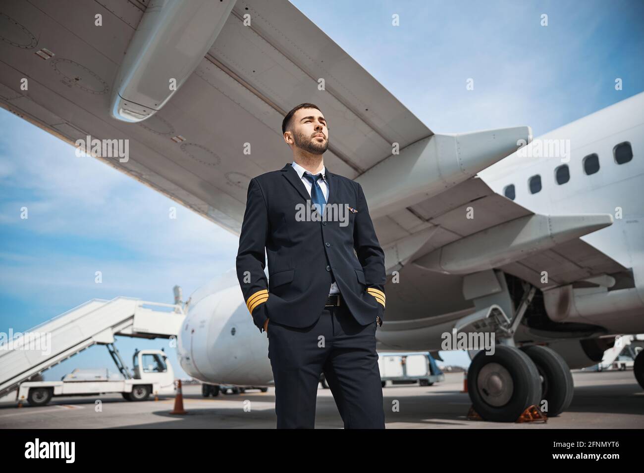 Confident pilot staring before himself near his plane Stock Photo - Alamy
