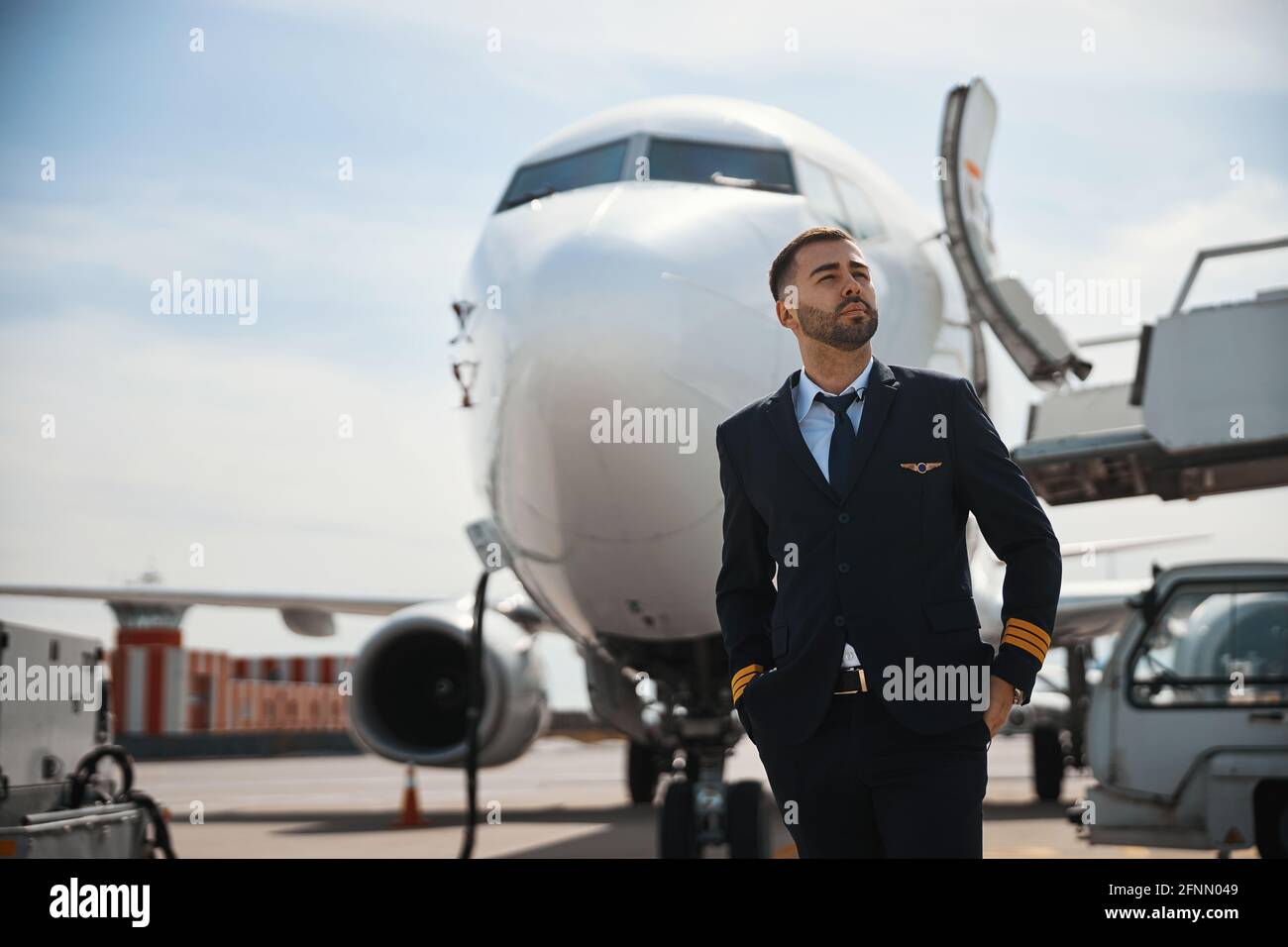 Inspired pilot in front of airplane nose Stock Photo - Alamy