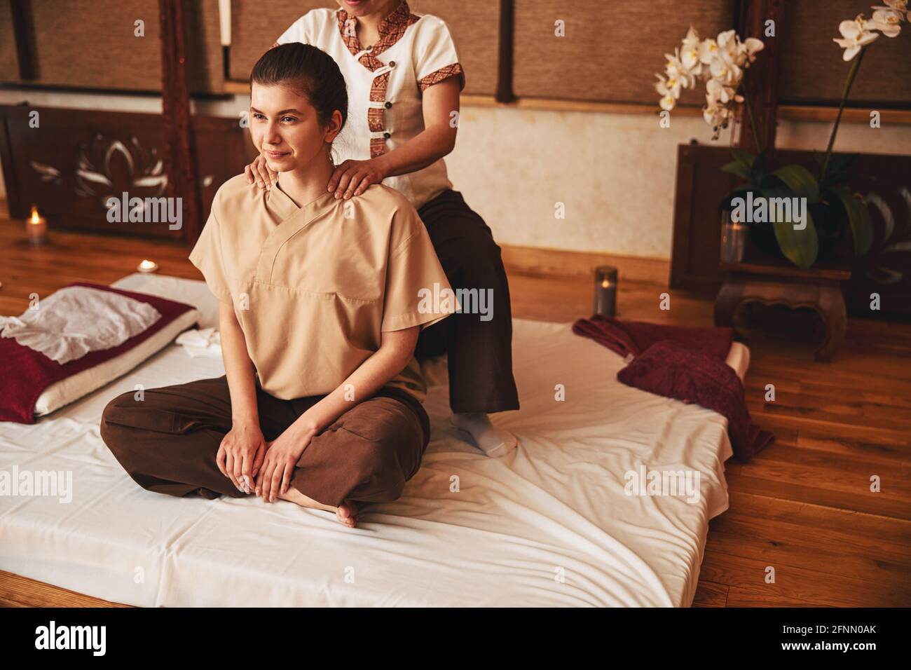 Calm woman in lotus pose getting neck massage Stock Photo - Alamy