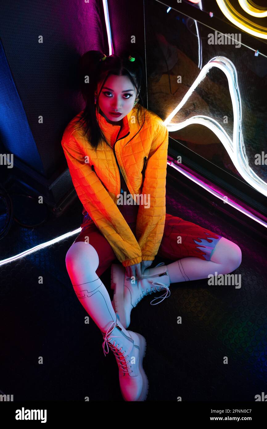 high angle view of young asian woman in bright clothing sitting on ...