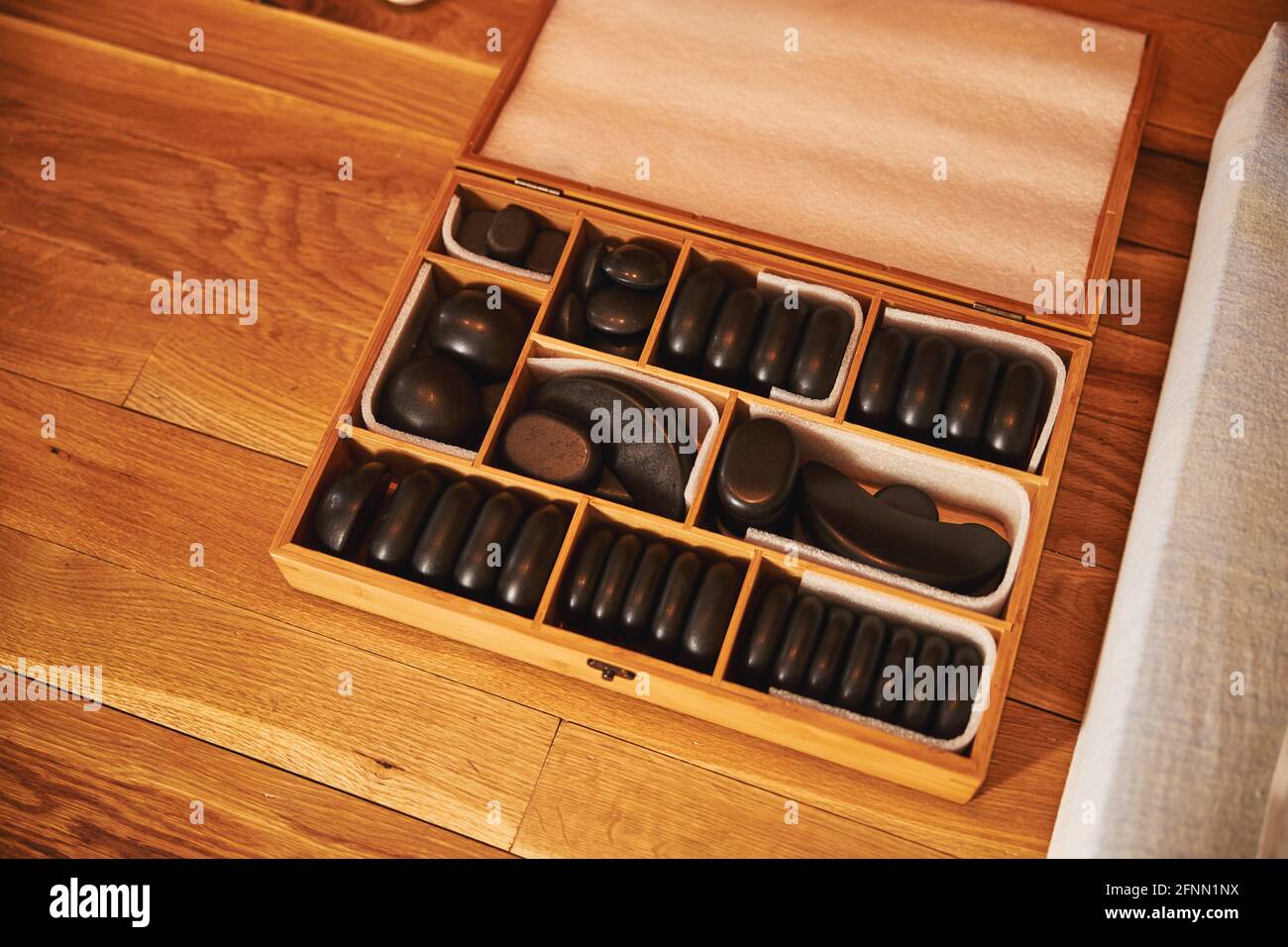 Box with black massage stones lying on the floor Stock Photo - Alamy