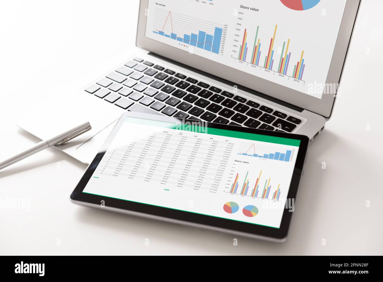 Business analytics applications on tablet and laptop. Financial data ...