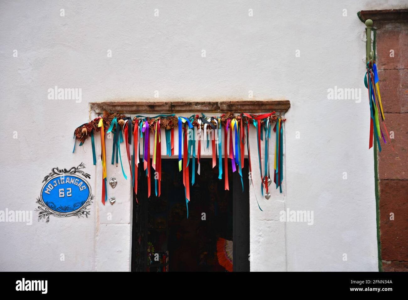 Local artisan shop facade with a white stucco wall and colorful satin ...
