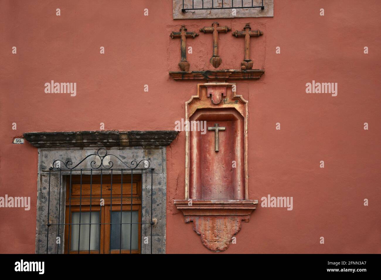 Gothic church facade with stone trimmed windows and religious ceramic ...