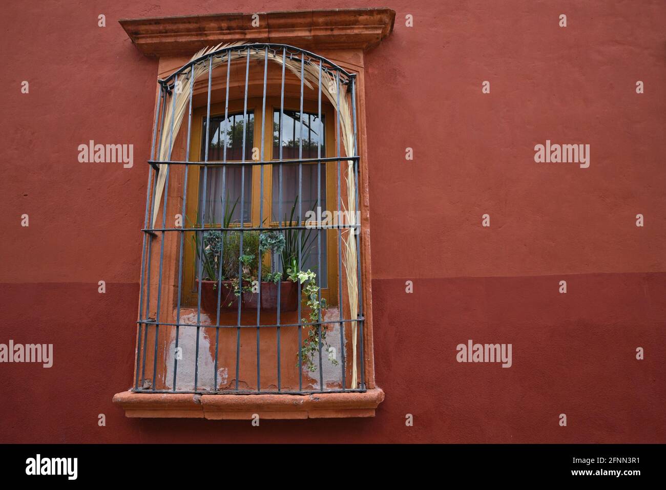 Colonial house window with stone trim and handcrafted iron grilles on a ...