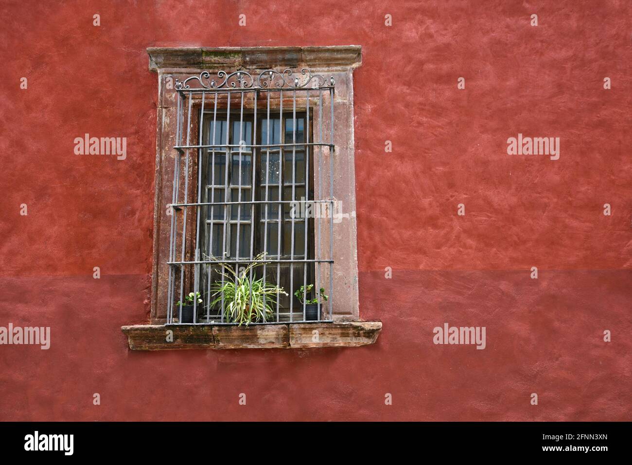 Colonial house window with stone trim and handcrafted iron grilles on a ...