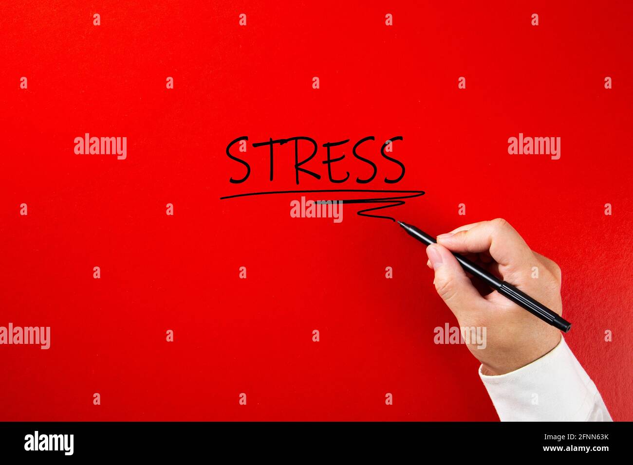 Male hand writing the word stress on red background Stock Photo - Alamy