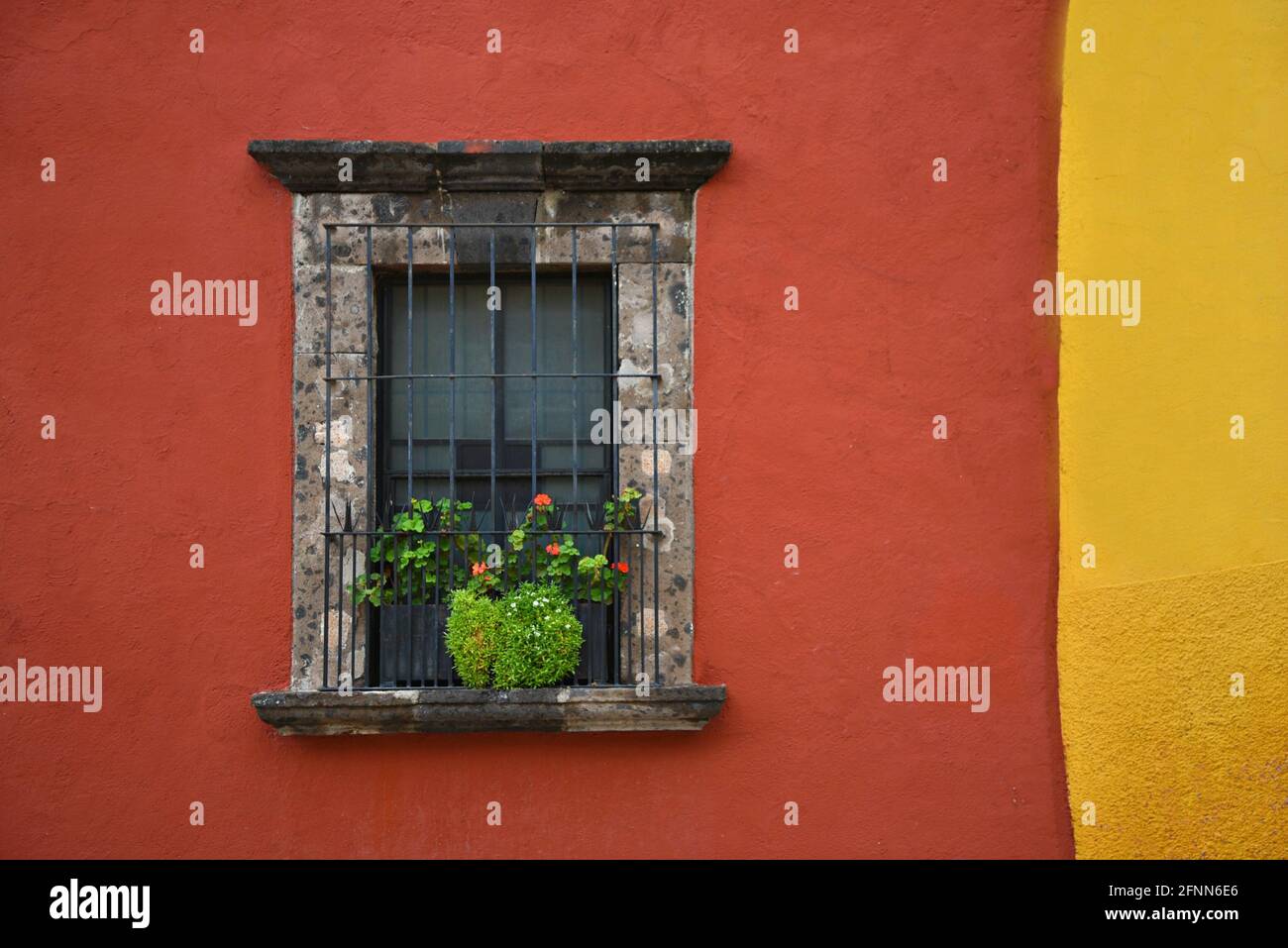 Colonial house window with stone trim and handcrafted iron grilles on a ...