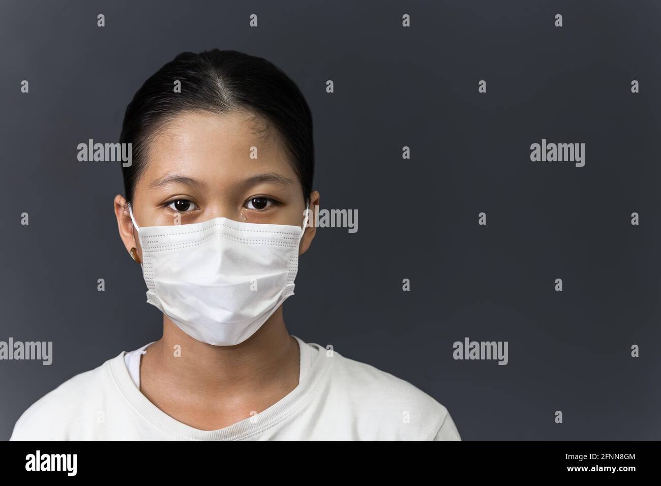 Asian young girl in protective mask is crying against covid-19 Stock ...