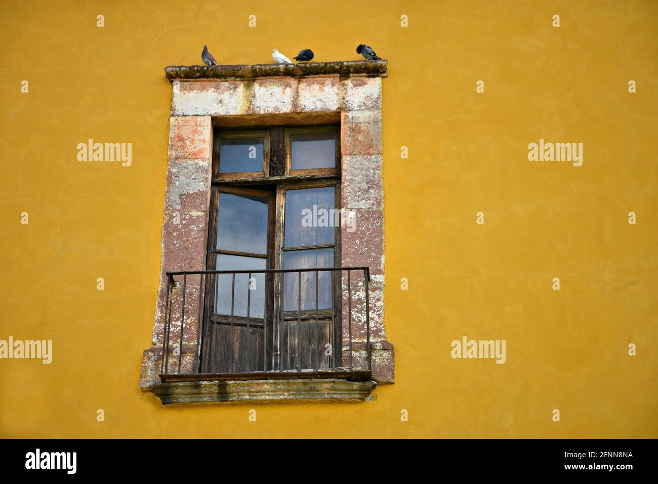 Colonial house window with stone trim and a handcrafted iron balcony ...