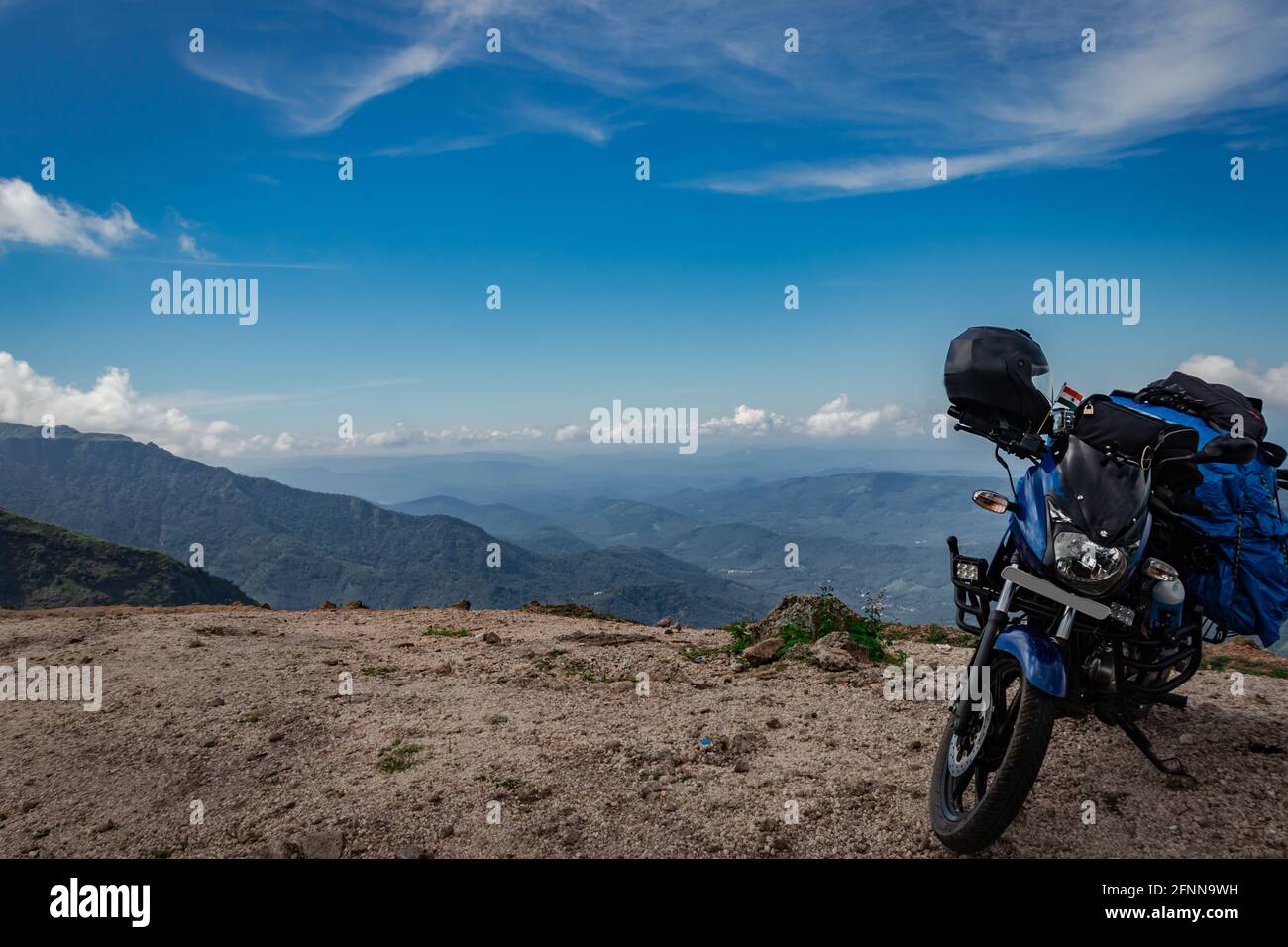 Solo traveler loaded bike with amazing background on hilltop image is taken at vagamon kerala ...