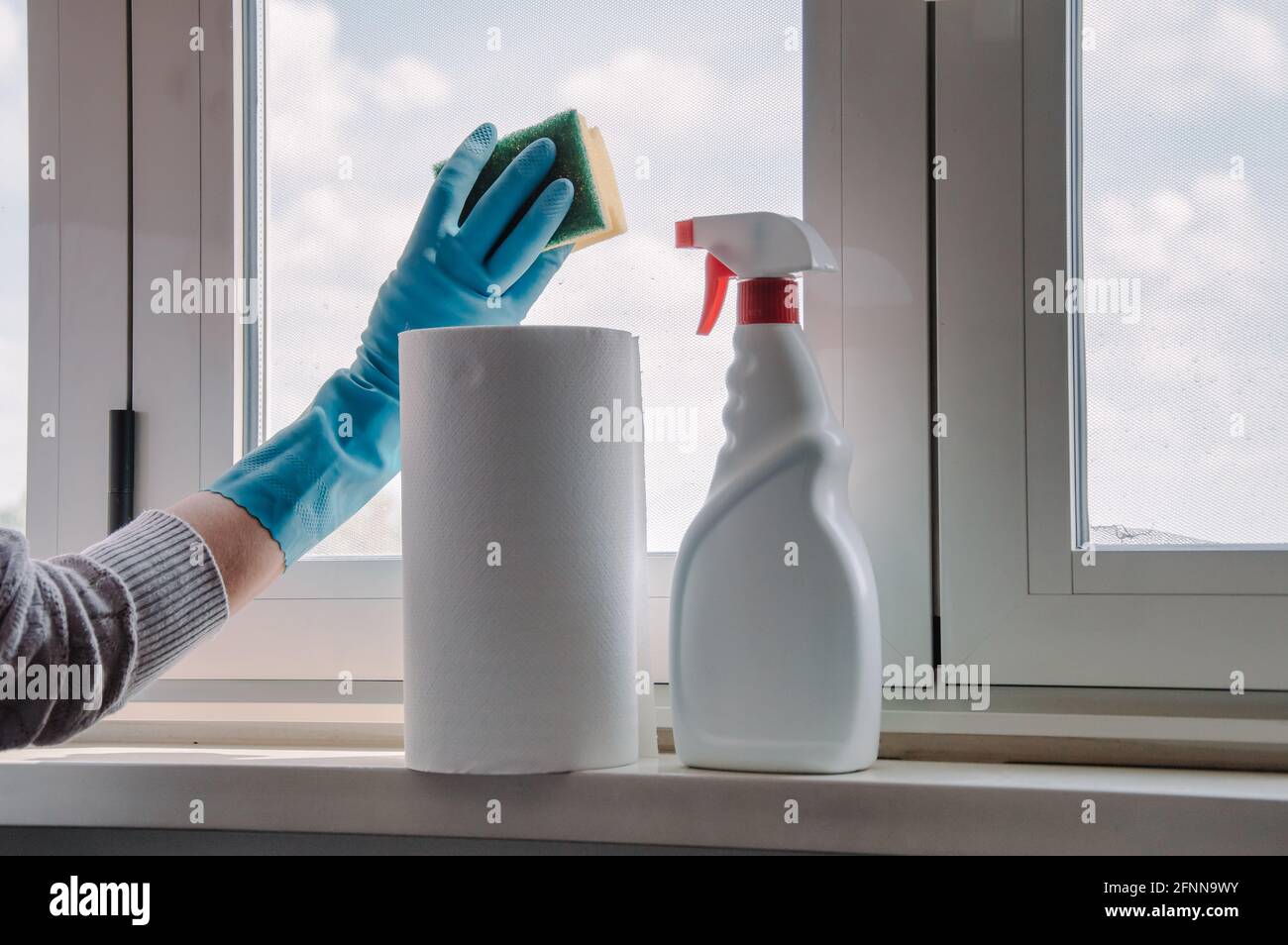 A set for cleaning windows. Hand in a blue glove. Cleaning tools and ...