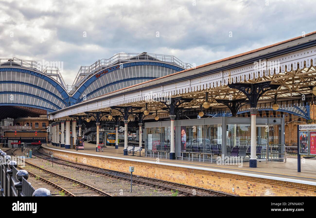 An ornate 19th Century railway platform canopy leading from two metal ...