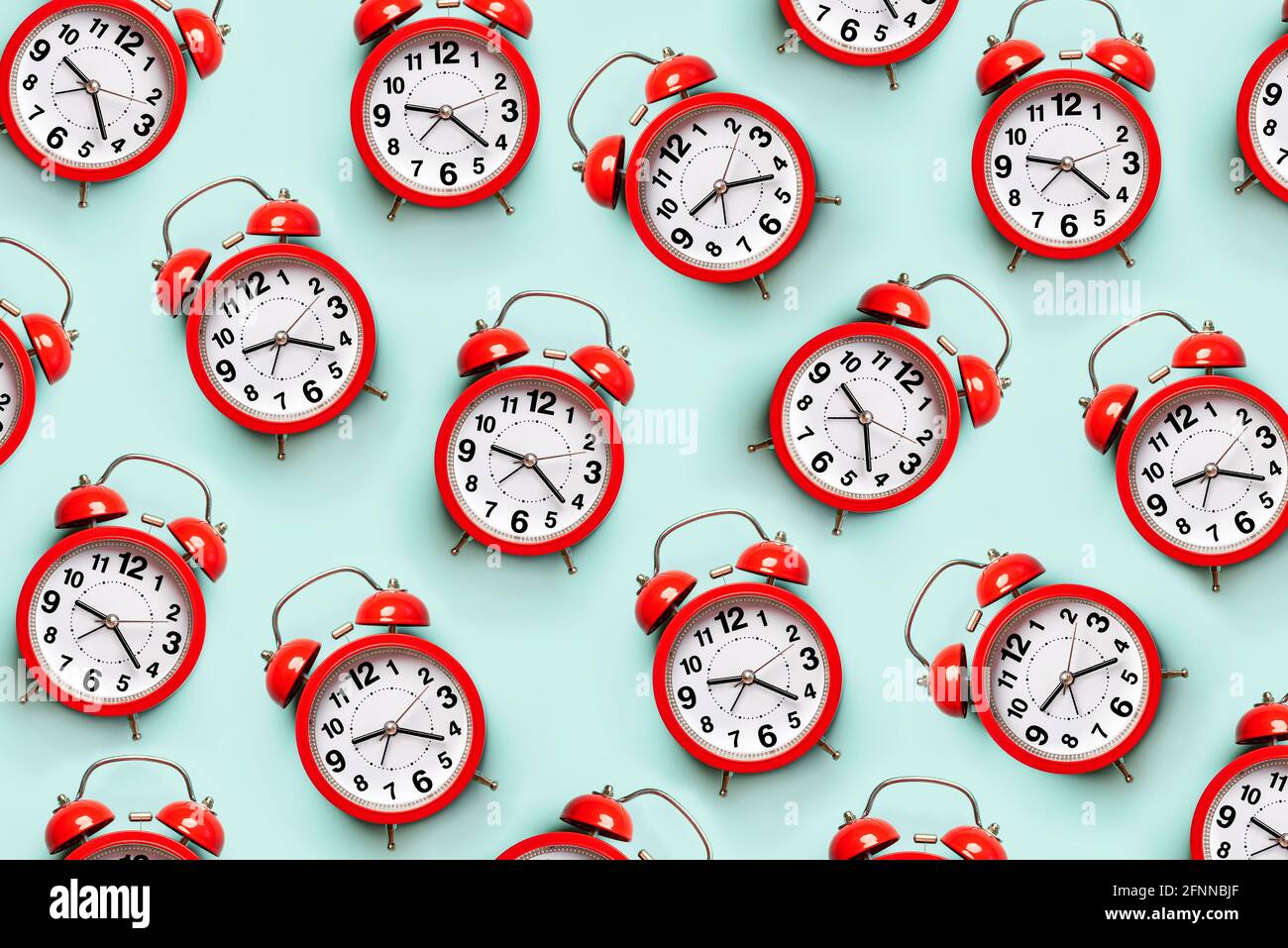 Top view of creative pattern made of red alarm clocks on a blue ...