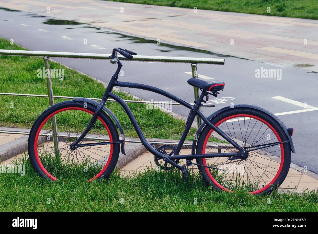 Bike path in the rain and wet bike at the railing Stock Photo - Alamy