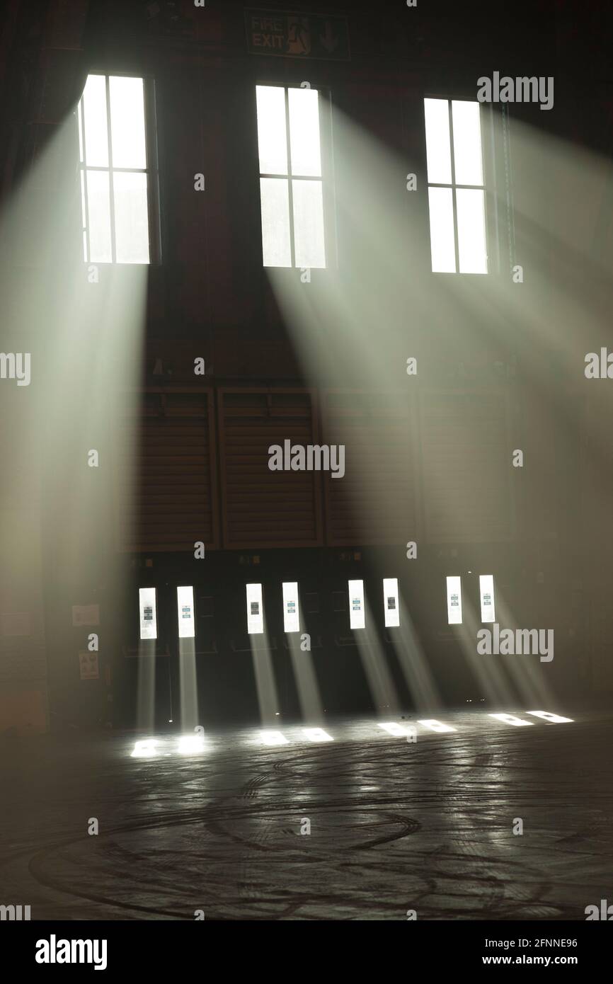 Atmospheric sunbeams streaming through the the windows of a large old ...