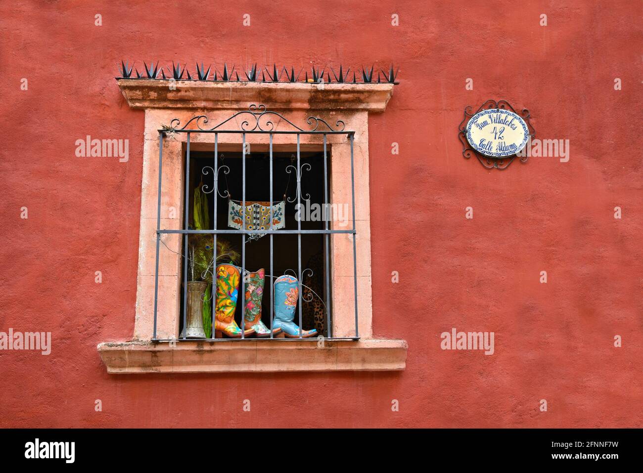 Local artisan shop window with handmade cowboy boots display on a ...