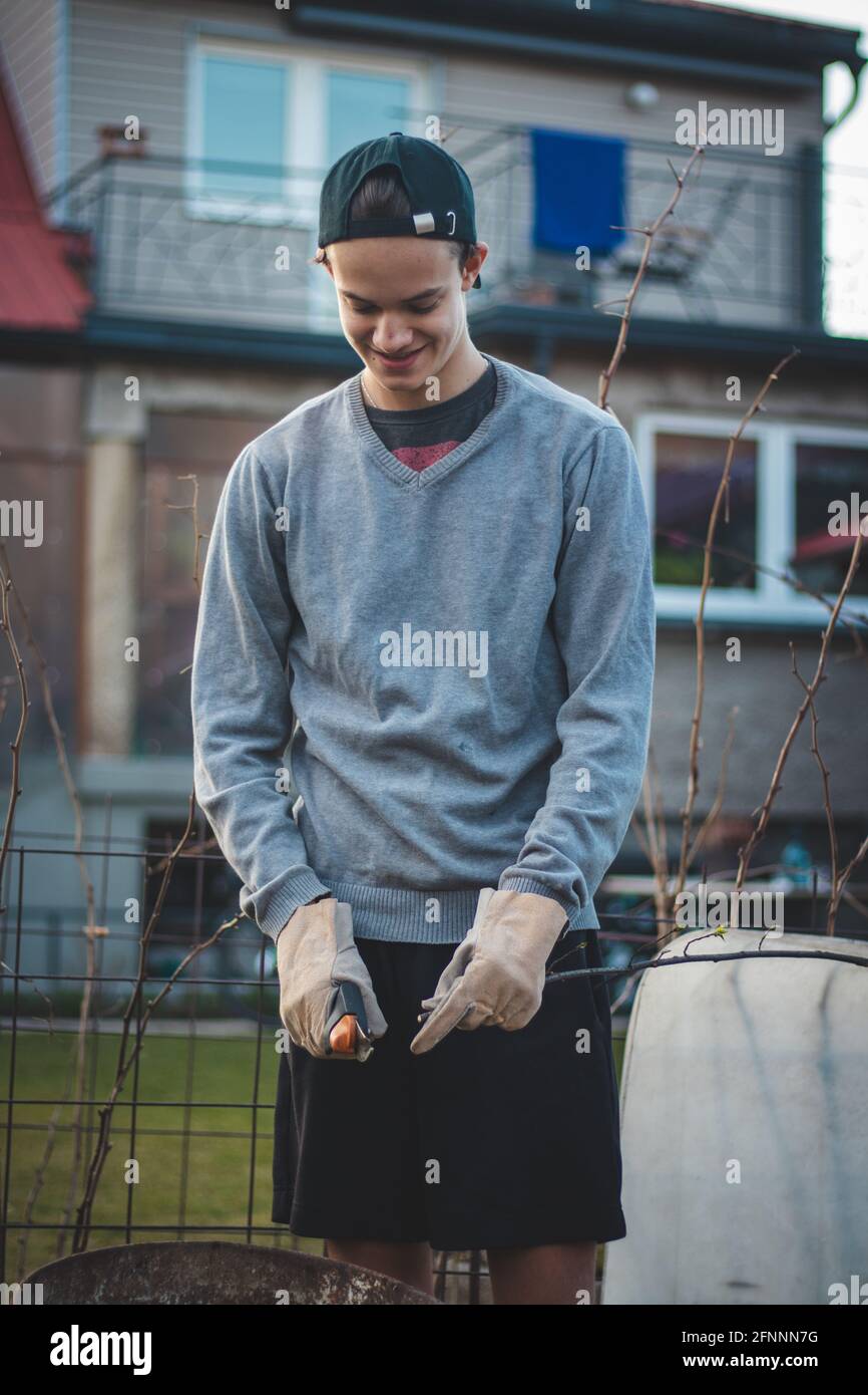 Swarthy boy of European descent with work gloves and special garden ...