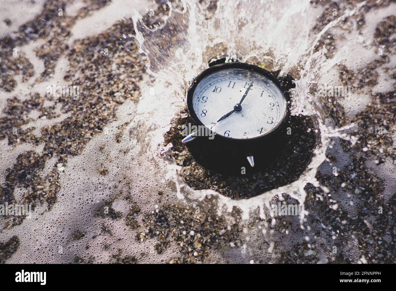 Alarm clock splashing in the beach water Stock Photo - Alamy