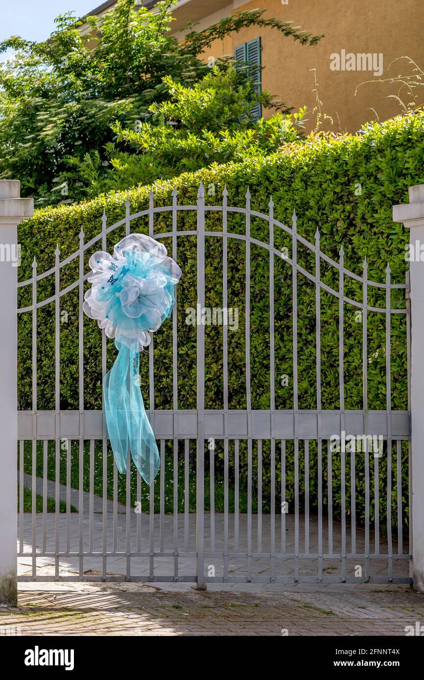 A large blue ribbon attached to the gate of a villa announces the birth ...