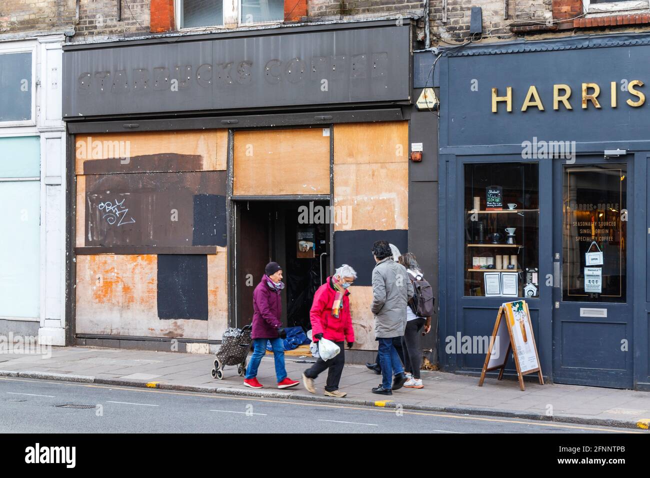 A closed down and boarded Starbucks Coffee shop next to a thriving ...