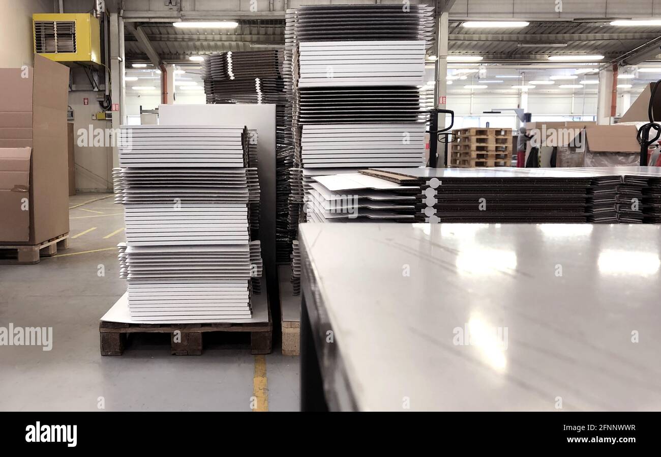 Carton factory or storage with pallets, shelves and stacks of paper and ...