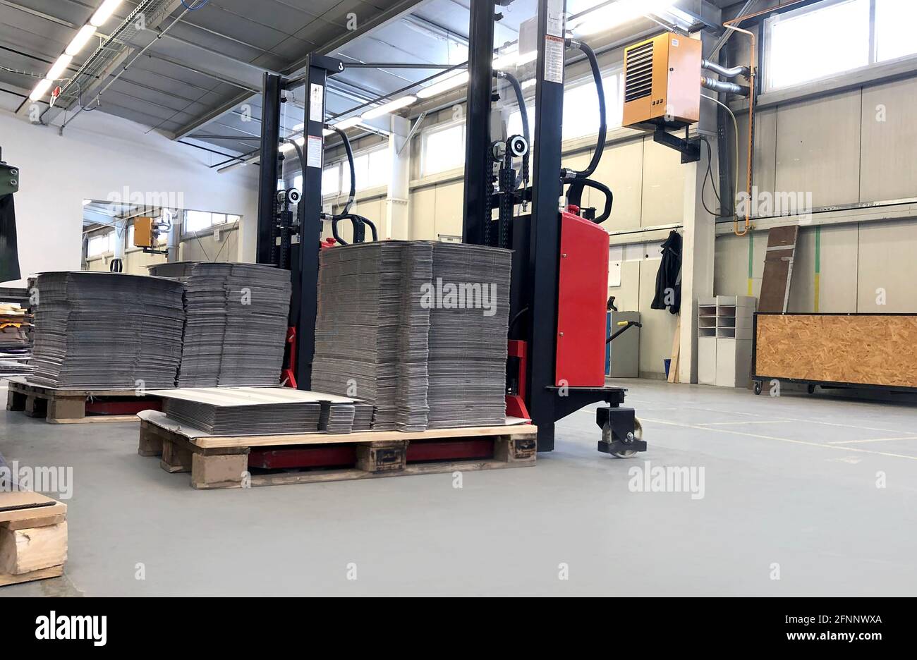 Carton factory or storage with pallets, shelves and stacks of paper and ...