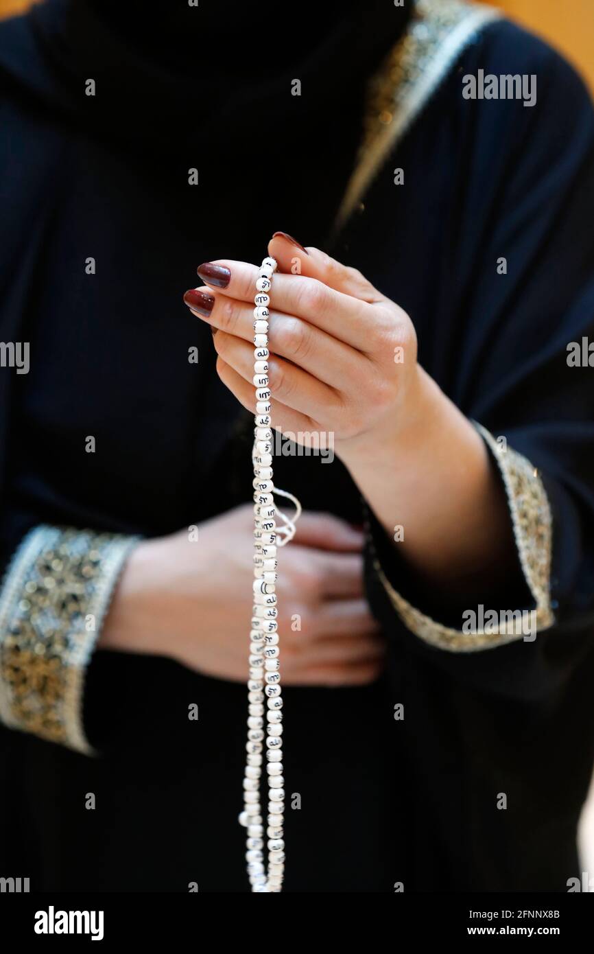 Close up view of a Muslim woman hands in abaya while holding rosary ...