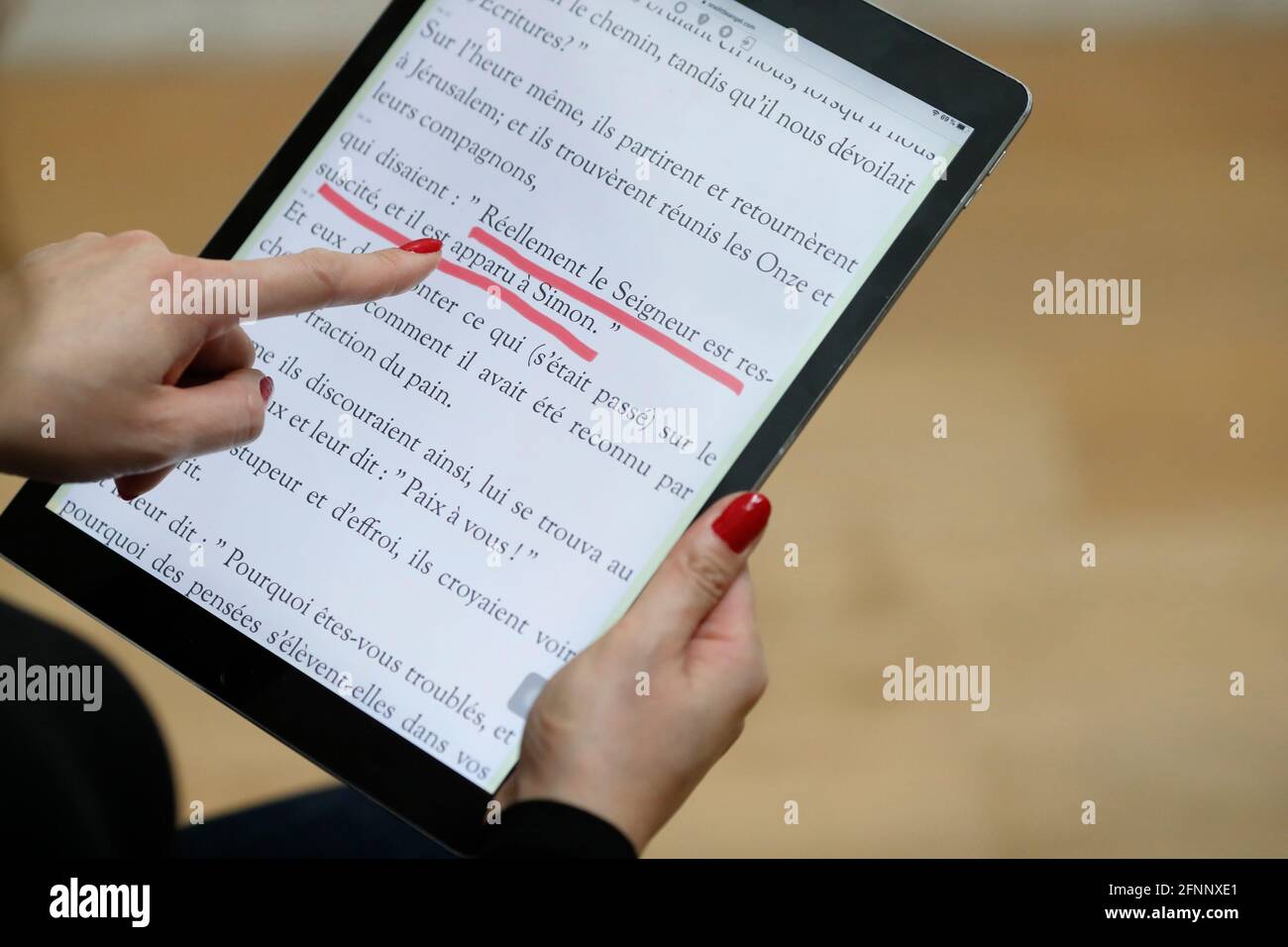 Woman reading and studying the gospels of the bible on a digital tablet ...