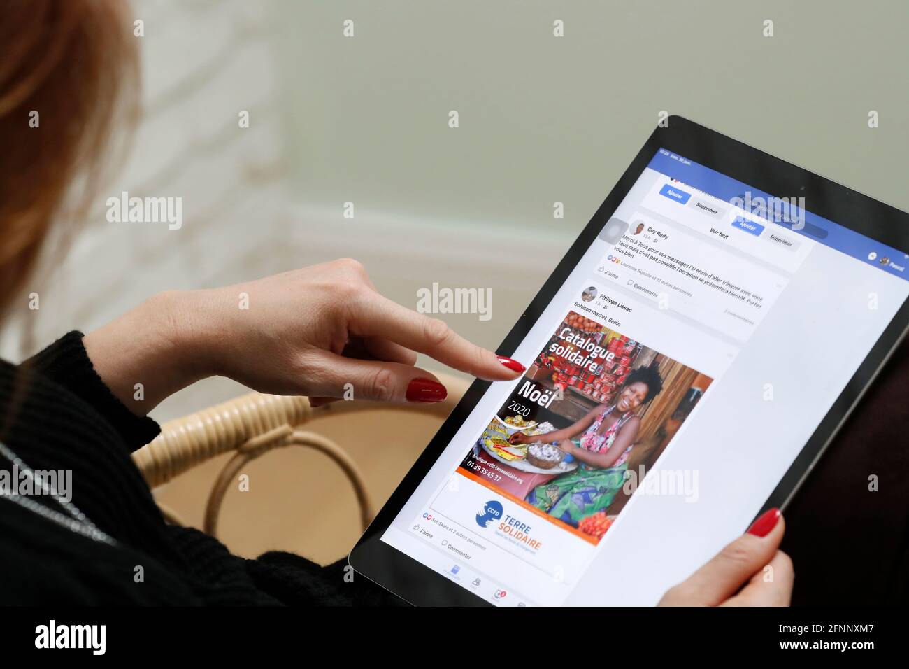 Woman reading facebook on an Apple iPad digital tablet. Facebook social ...