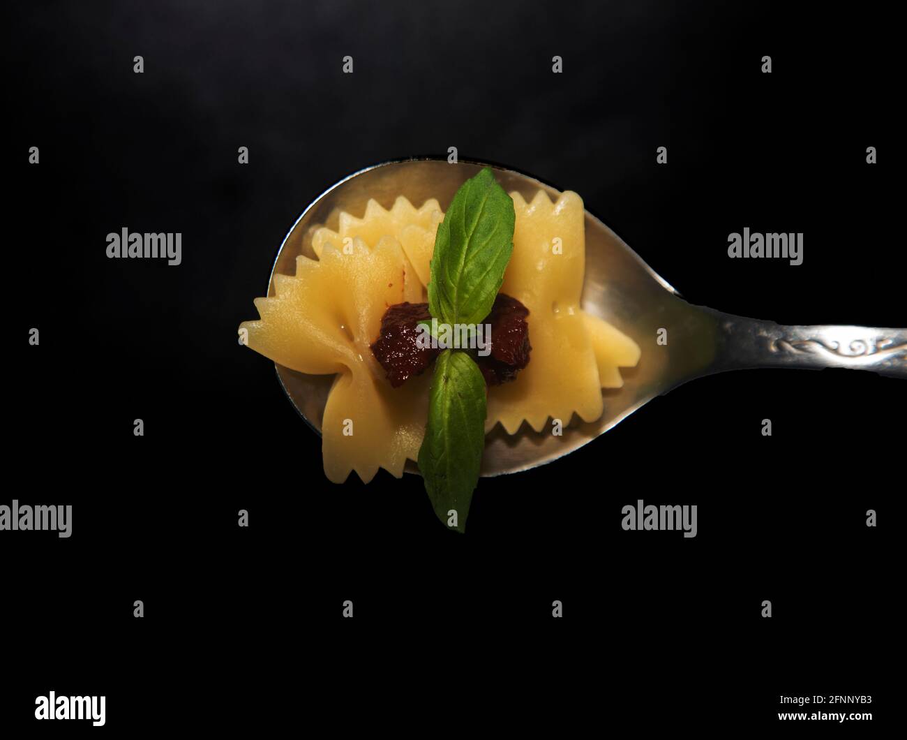Pasta Black Background on spoon Spaghetti Tomato Basil Stock Photo - Alamy