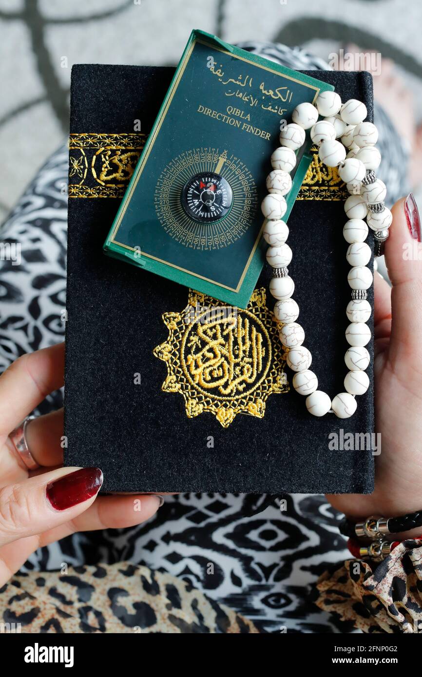 Muslim woman holding Quran, Qibla compass and prayer beads ( misbaha ...