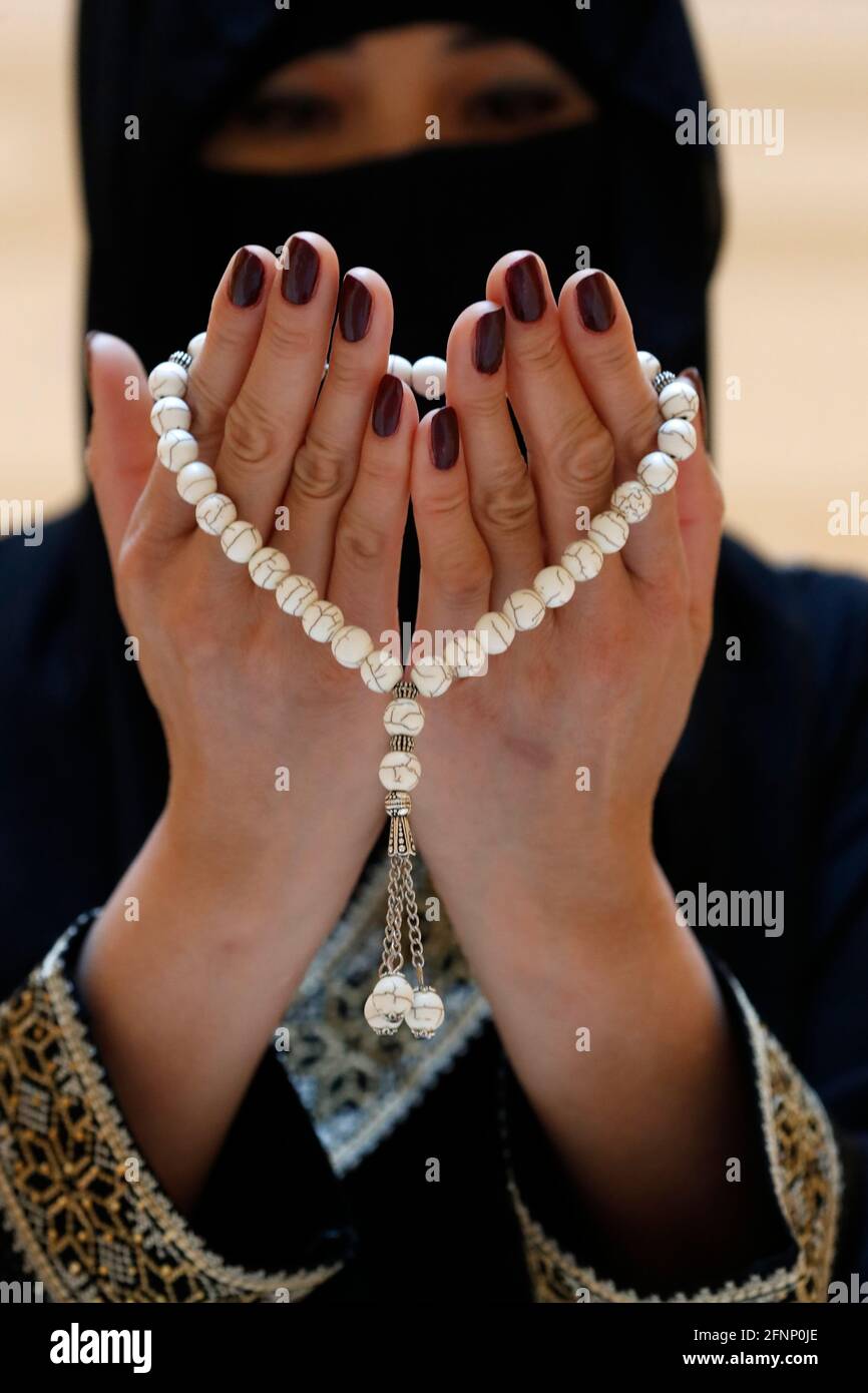 Close up view of a Muslim woman hands in abaya while holding rosary ...