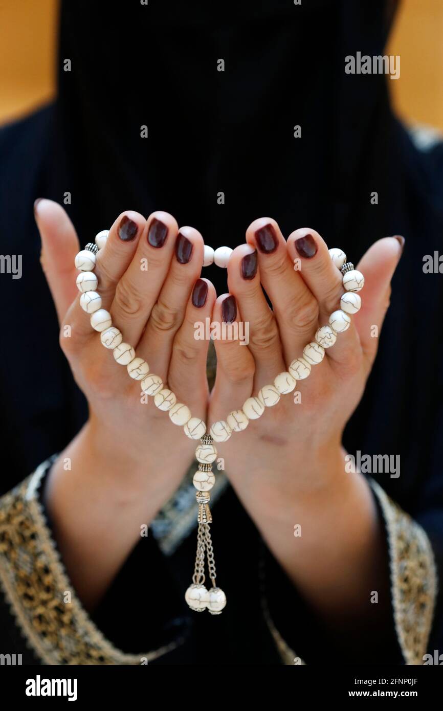 Close up view of a Muslim woman hands in abaya while holding rosary ...