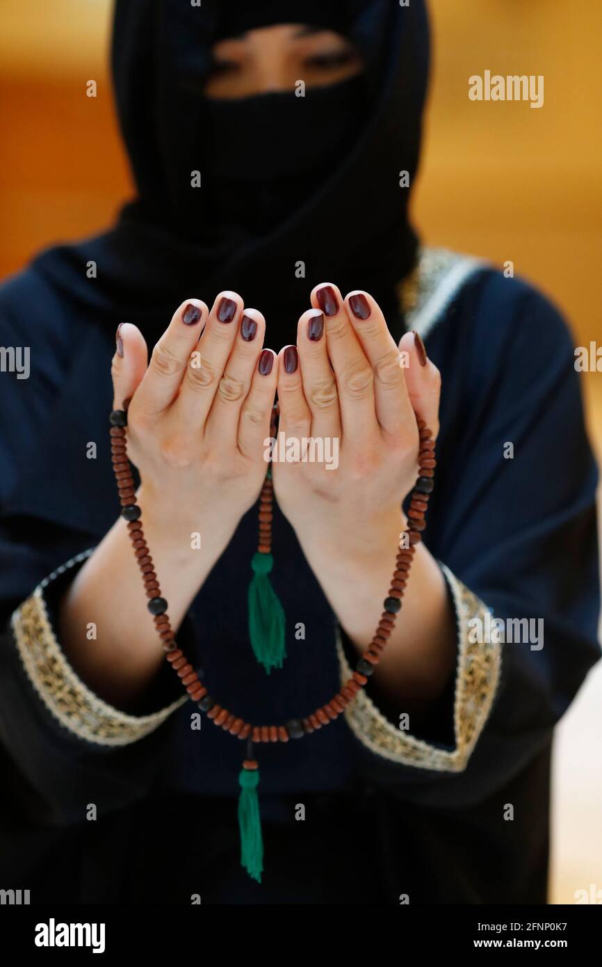 Close up view of a Muslim woman hands in abaya while holding rosary ...