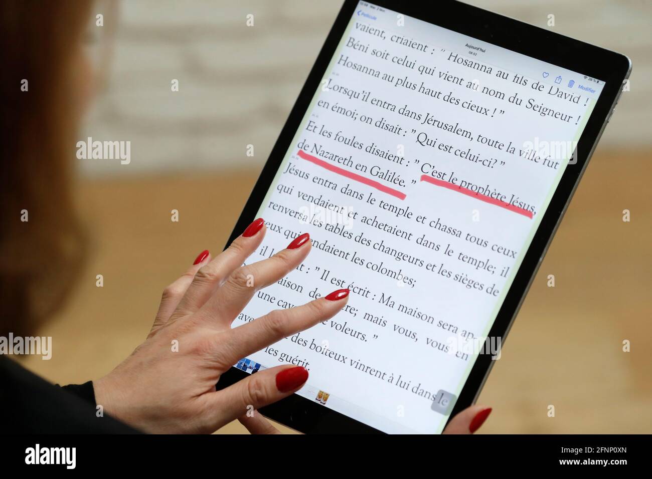 Woman reading and studying the gospels of the bible on a digital tablet ...