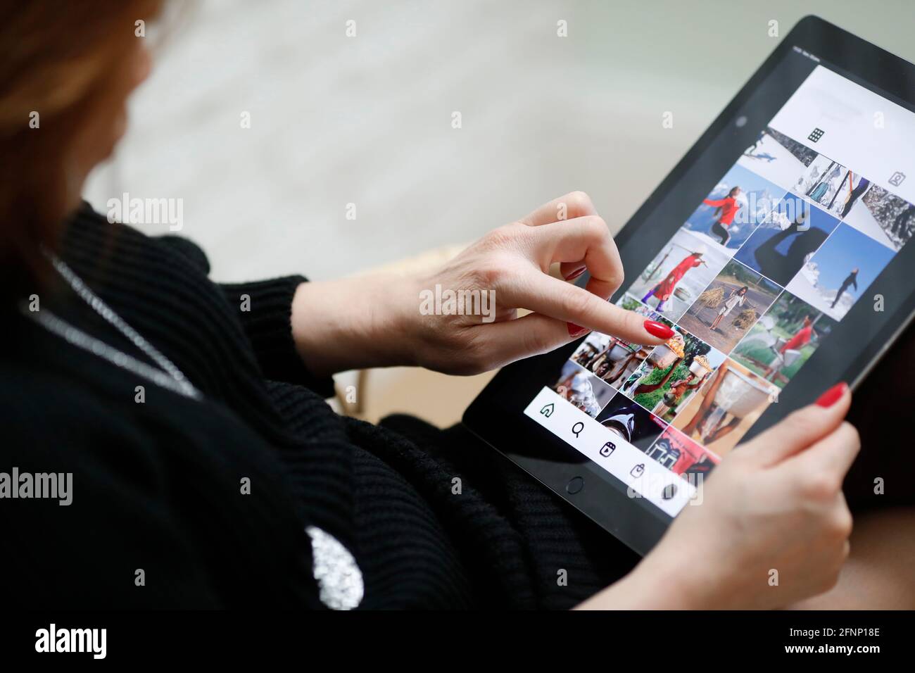 Woman reading Instagram on an Apple iPad digital tablet. Instagram ...