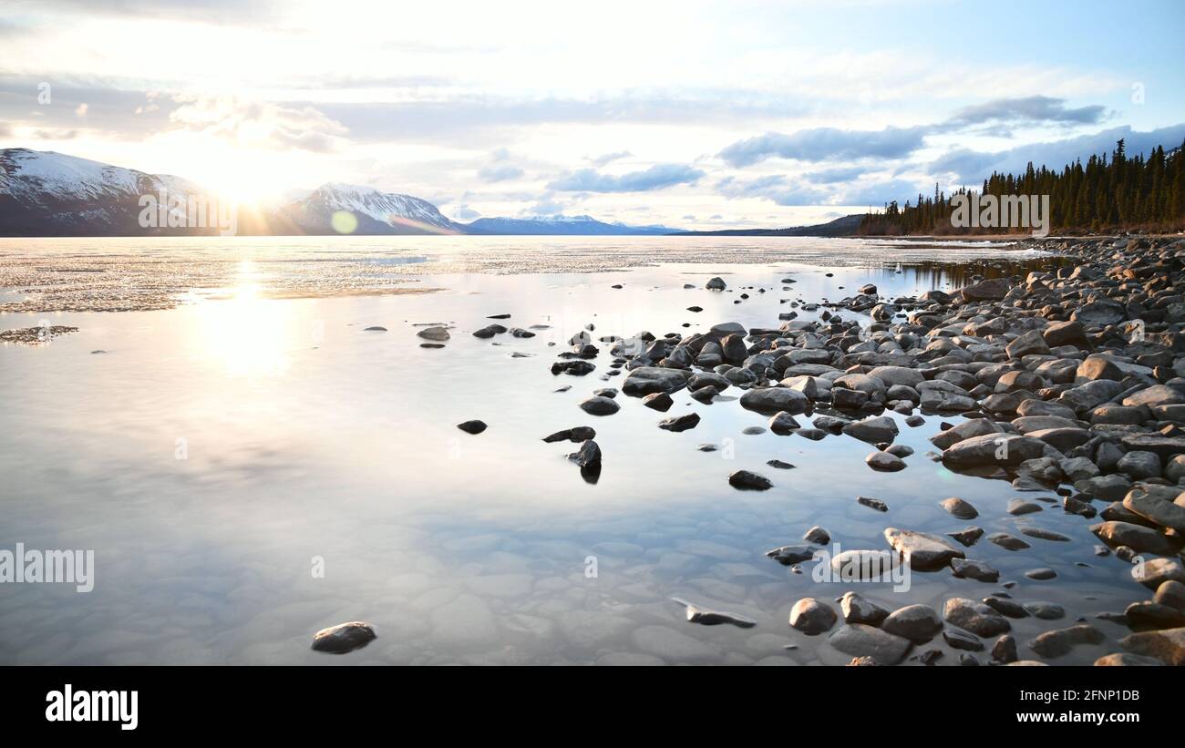 Stunning spring time lake with a lakeshore scene. Ice in distance ...