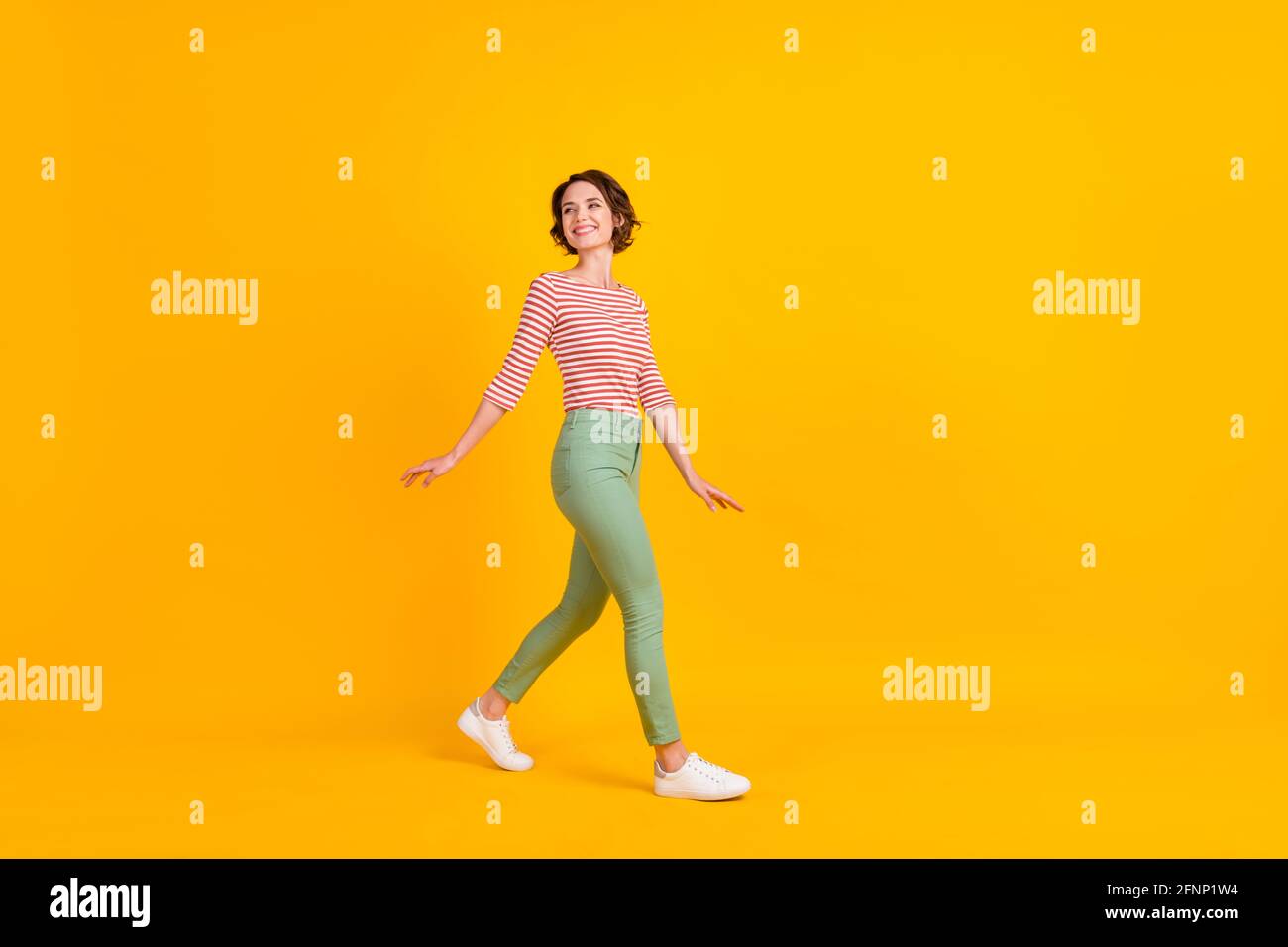 Full length photo of charming shiny woman wear striped outfit walking ...