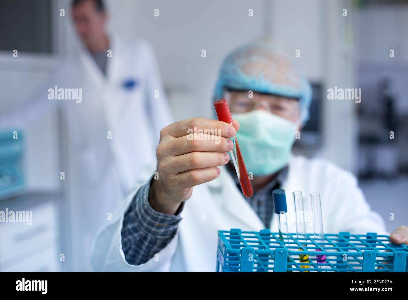 Close up of doctor's hand holding test tube with blood. Epidemic ...