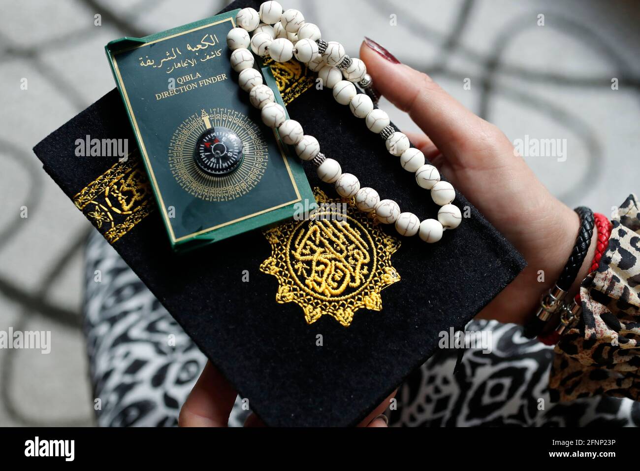 Muslim woman holding Quran, Qibla compass and prayer beads ( misbaha ...