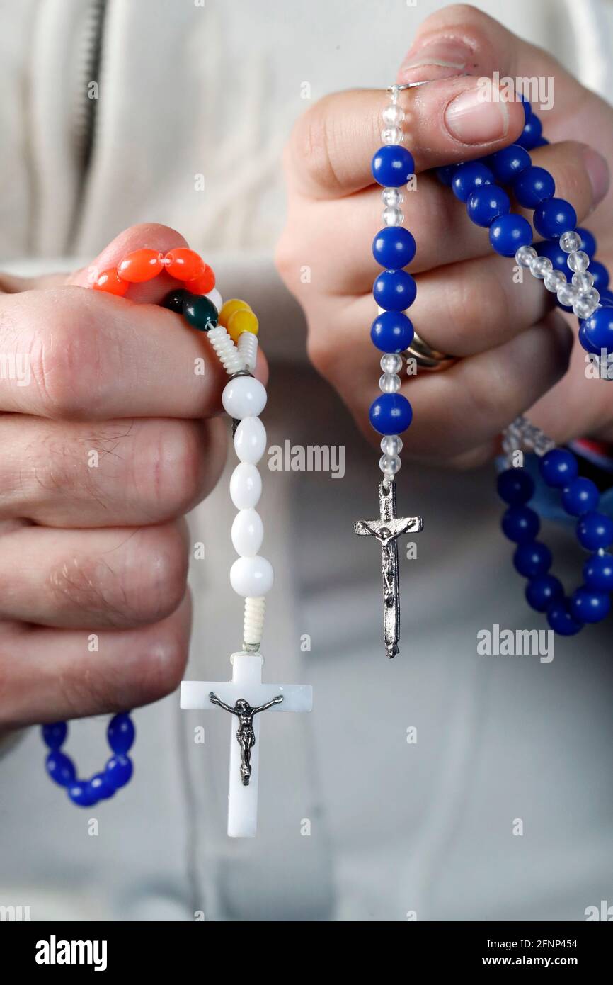 Catholic man and woman praying together at home. Close up on hands with ...