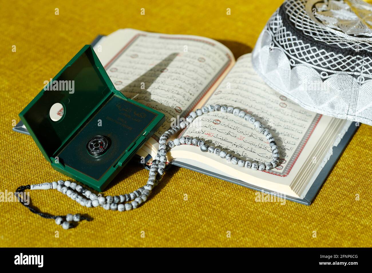 Quran, Kufi cap, Qibla compass and prayer beads ( misbaha ) . Symbols ...