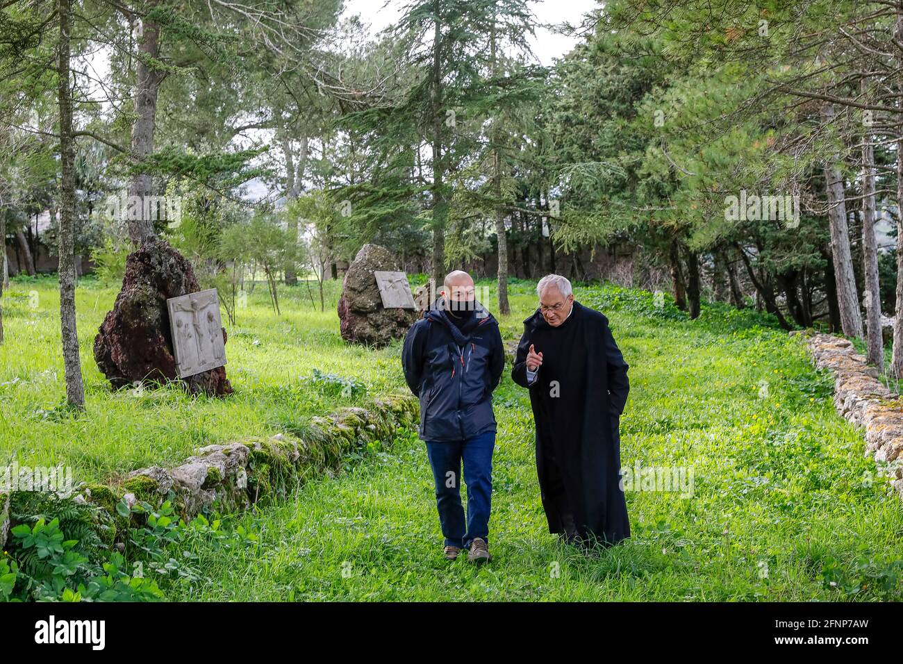 Lay man and benedictine monk in San Pietro di Sorres basilica garden ...