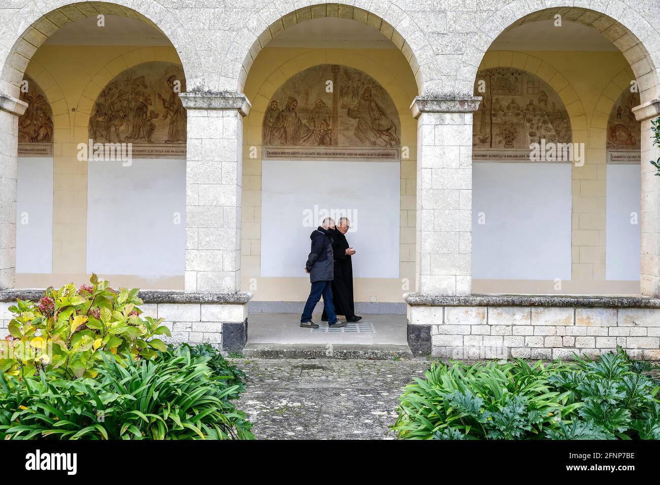 Lay man and benedictine monk in San Pietro di Sorres basilica cloister ...