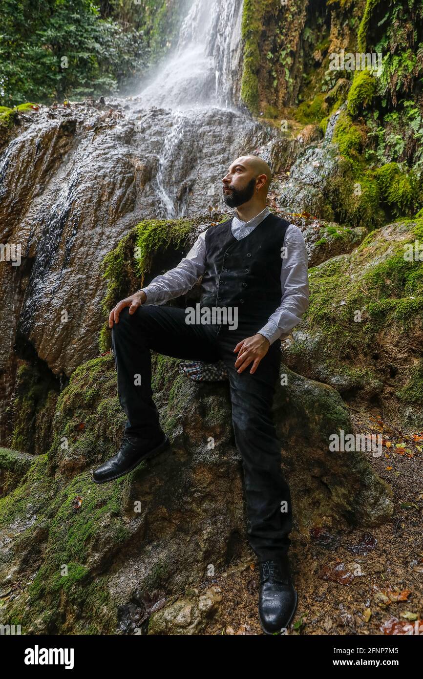 Person sitting beside a waterfall hi-res stock photography and images ...