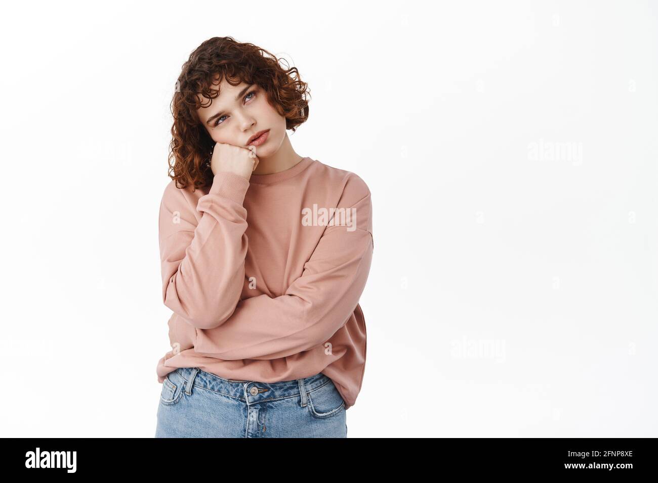 Annoyed and bored curly-haired girl, roll her eyes and sulk, lean head ...