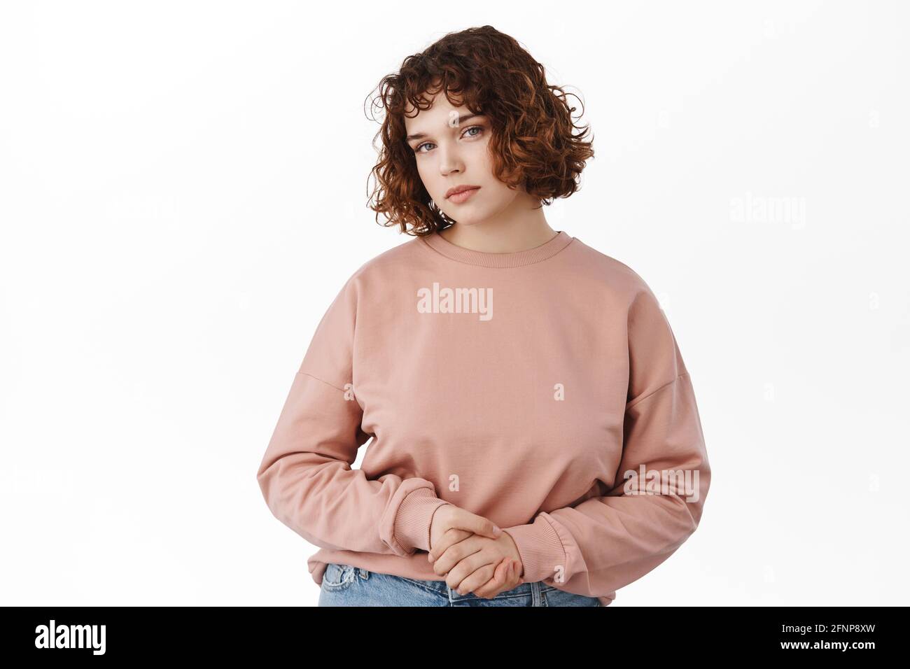 Young female student with curly short hair, hold hands together in ...