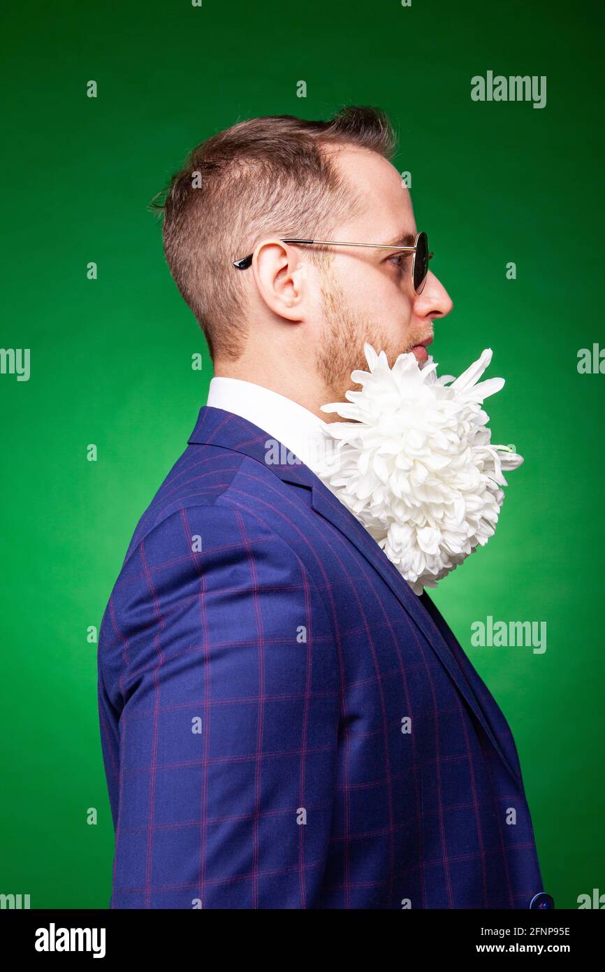 Self assured male in elegant suit and with tender white flowers in ...